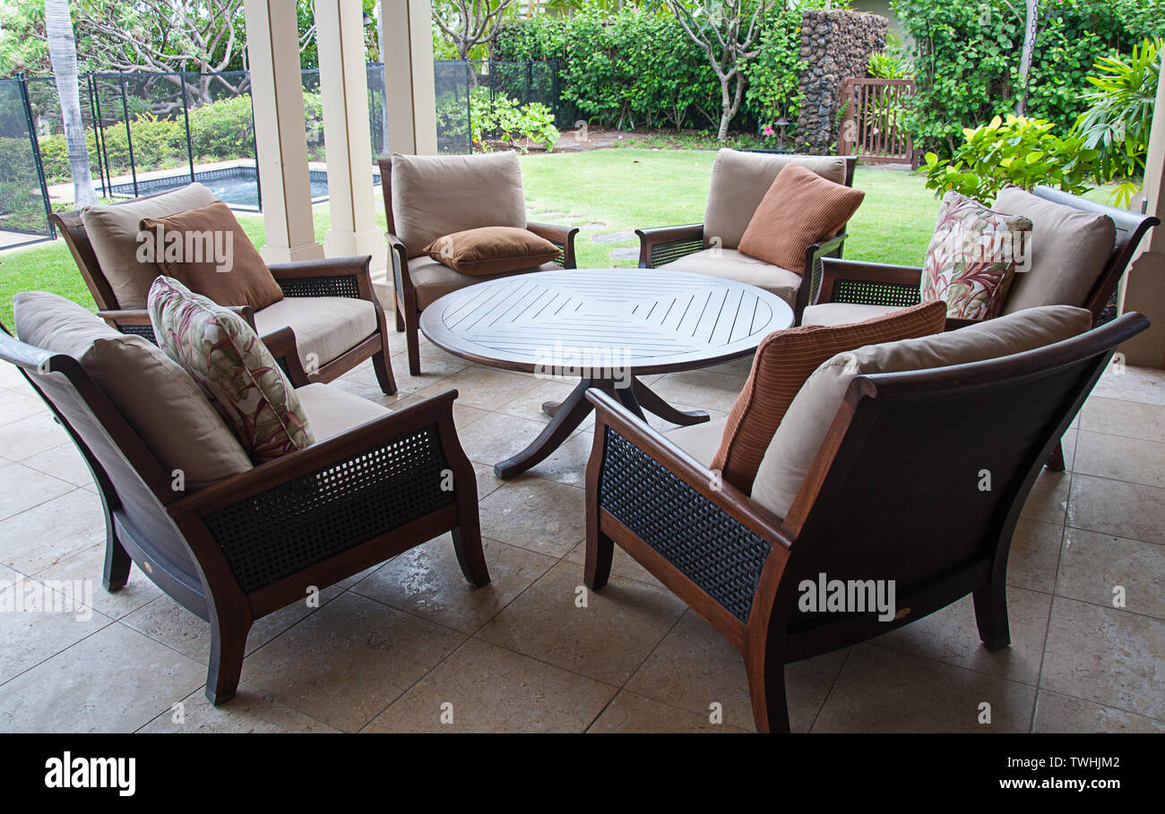 Seating area on tropical porch with a round table and comfortable ...