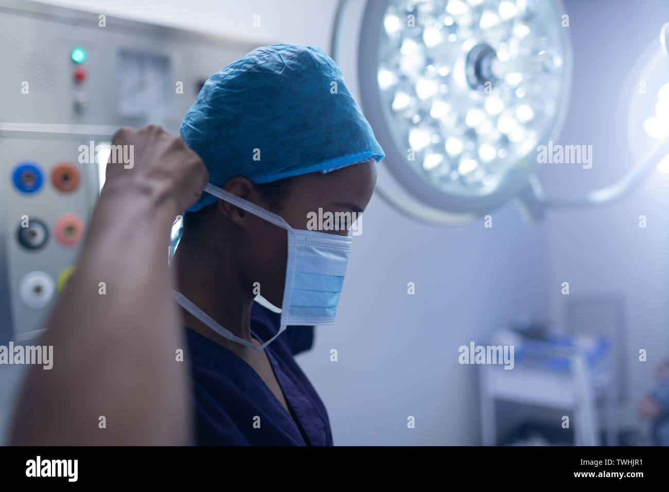 Female surgeon wearing surgical mask in operation theater at hospital ...