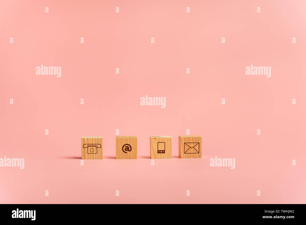 Four wooden cubes in a row with contact and communication icons on them ...