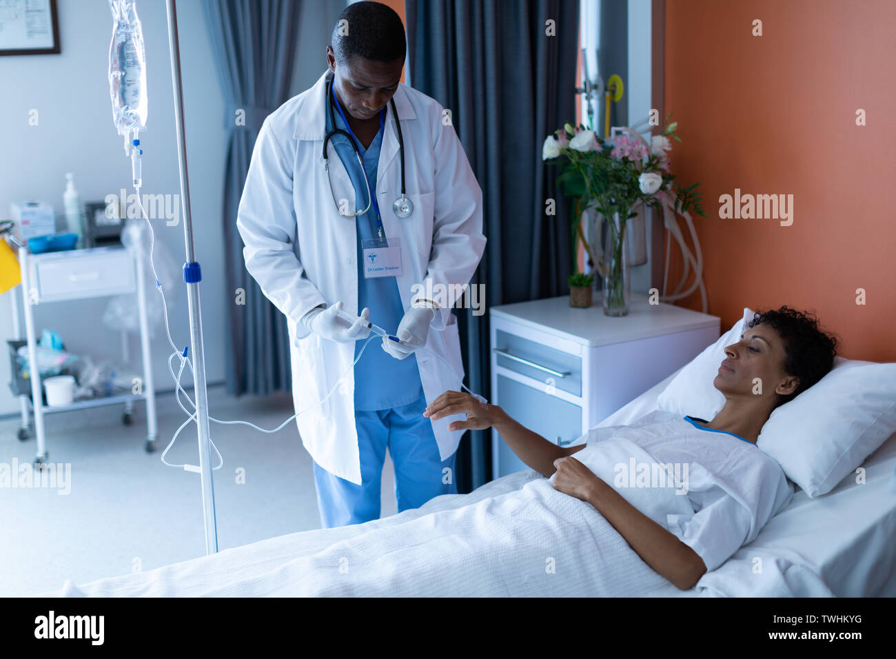 Male doctor injecting injection to female patients intravenous drip in ...