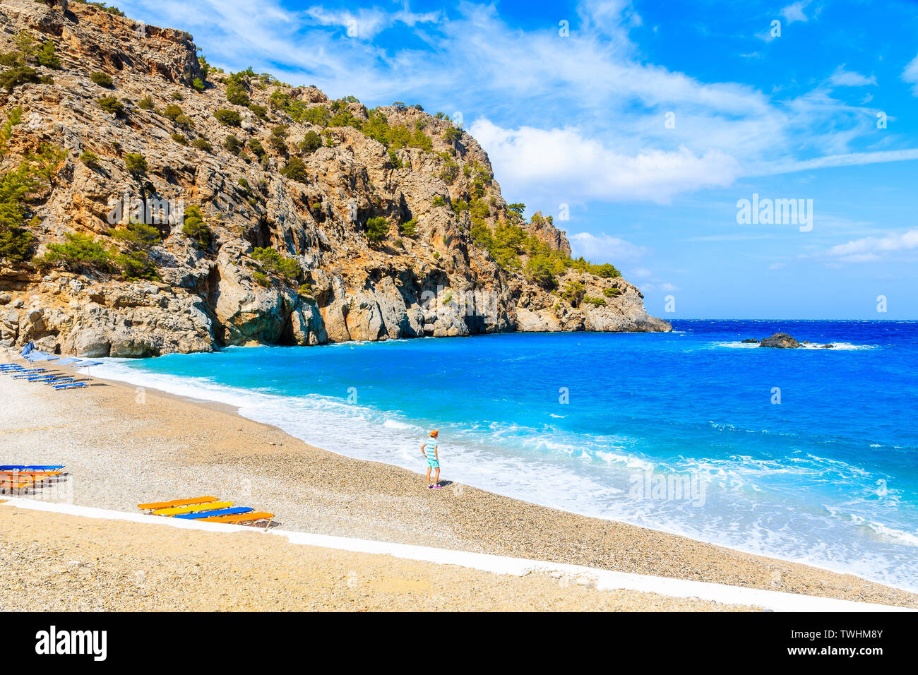 Young woman tourist standing on idyllic Achata beach and looking at ...