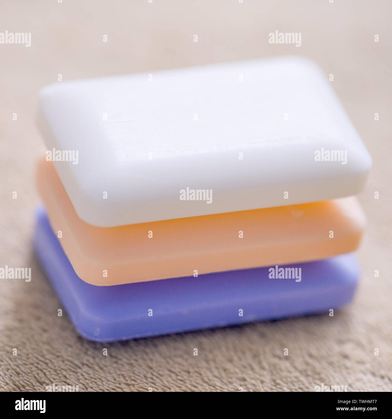 Three hard bars of soap on a pale brown towel. Side view Stock Photo ...