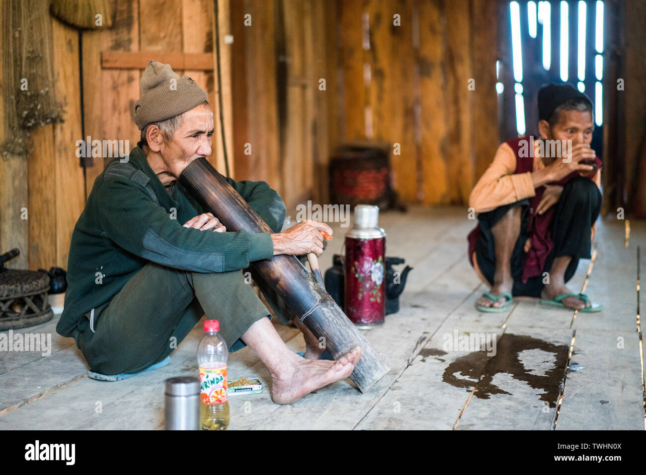 man smoking opium by traditional tobacco pipe in the akha Pixor village ...