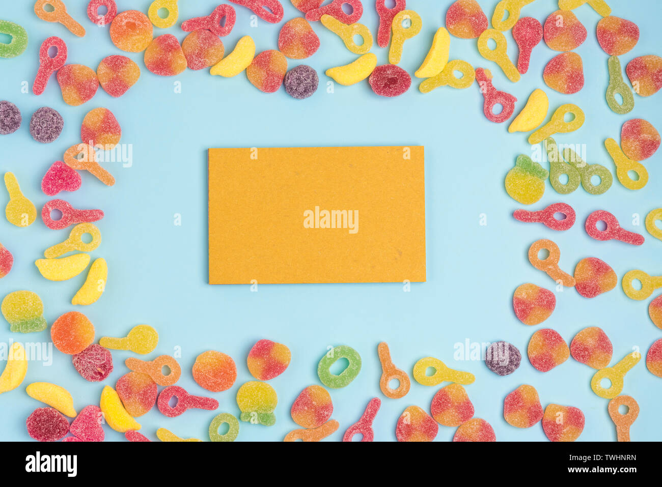 Blue paper background with sugary jellies and blank notepad. Place for ...