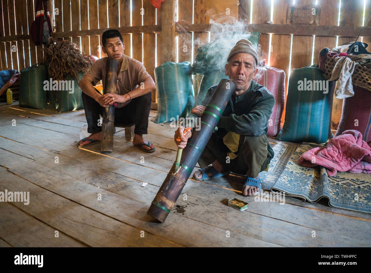 man smoking opium by traditional tobacco pipe in the akha Pixor village ...
