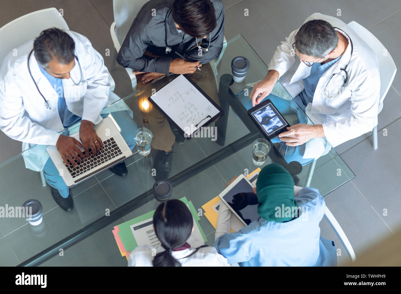 Medical team working together at table in hospital Stock Photo - Alamy