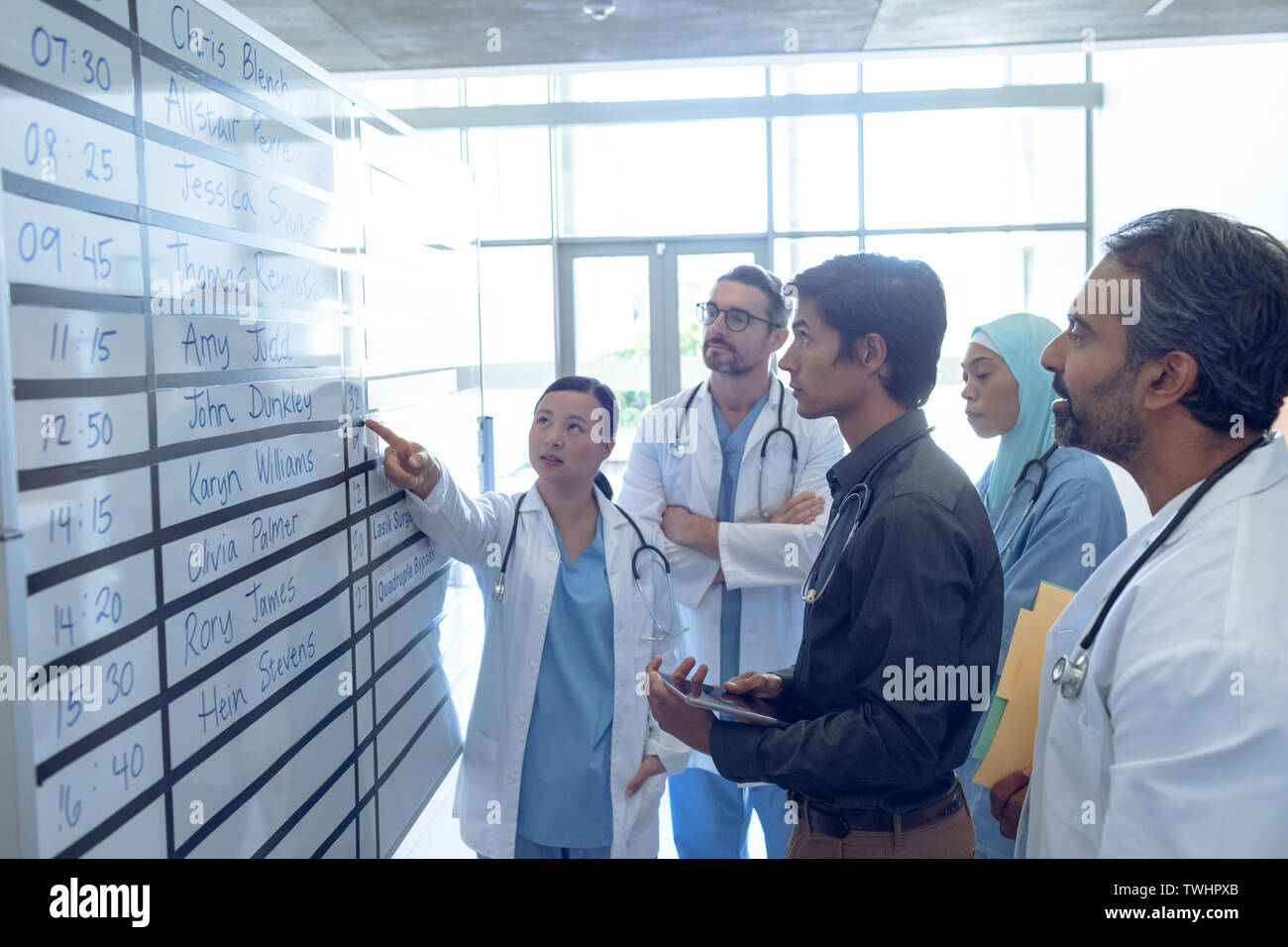 Medical team of doctors discussing their shifts on chart at hospital ...