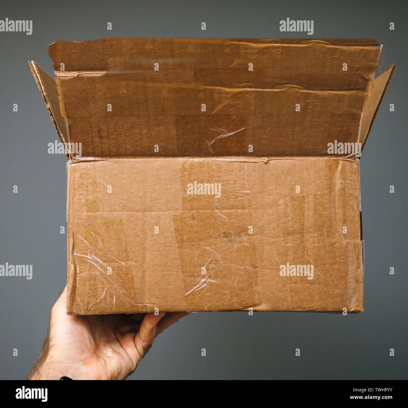 Man hand holding open cardboard box after before unboxing with ...