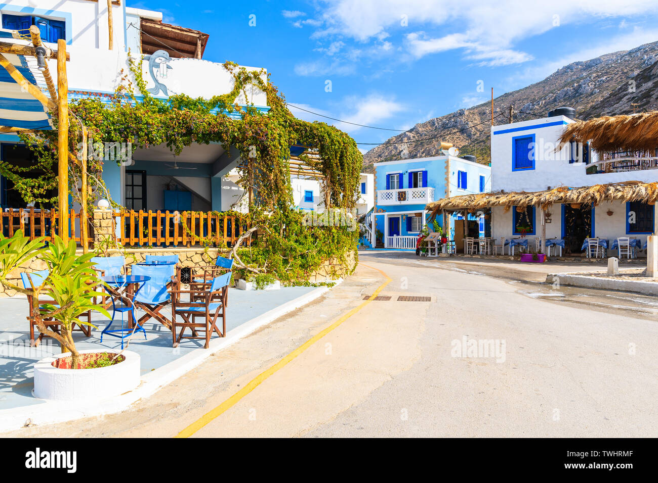 Street with traditional Greek houses and tavernas in Finiki port on ...