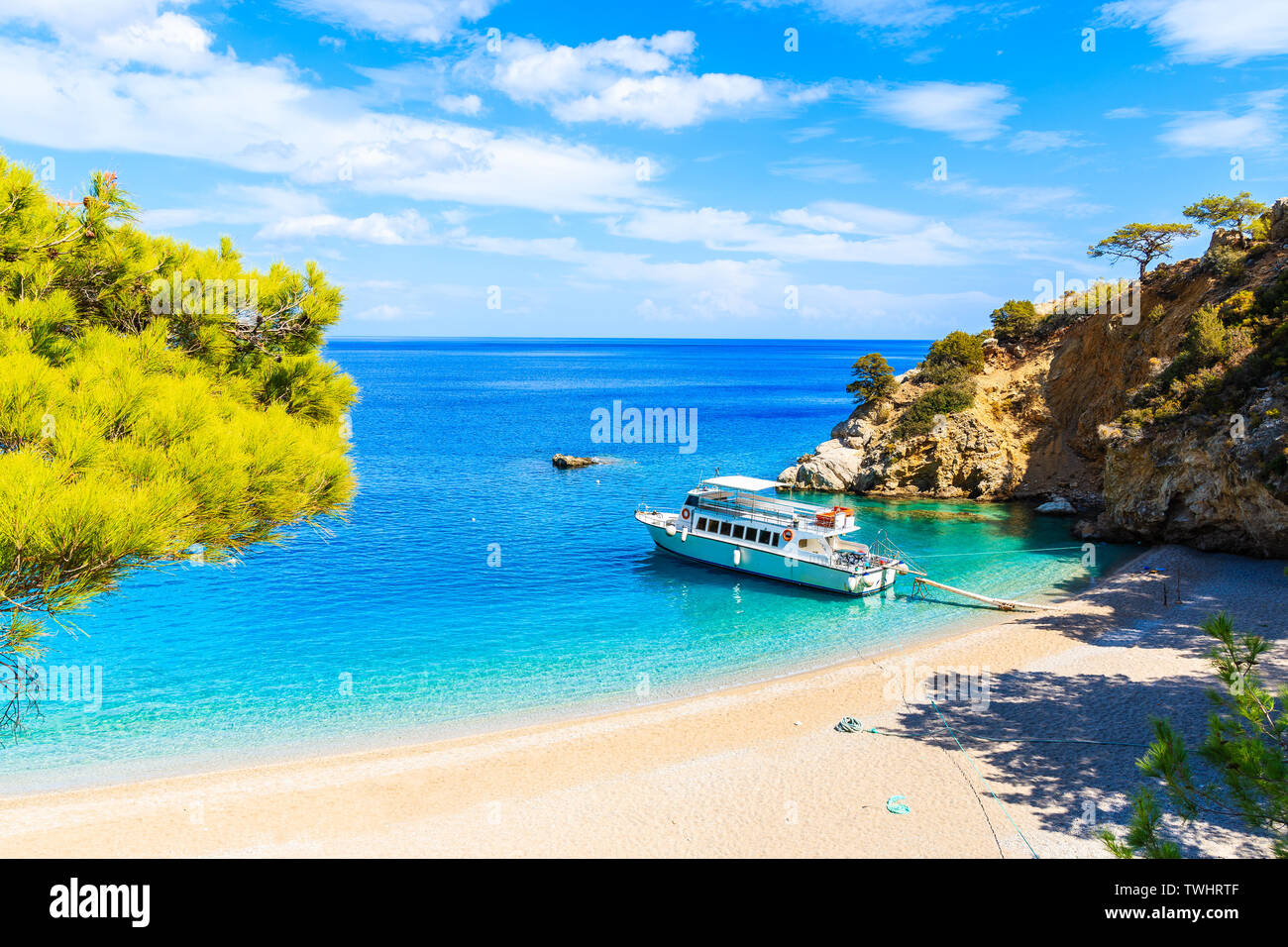 Tourist boat on beautiful Apella beach with azure calm sea water ...