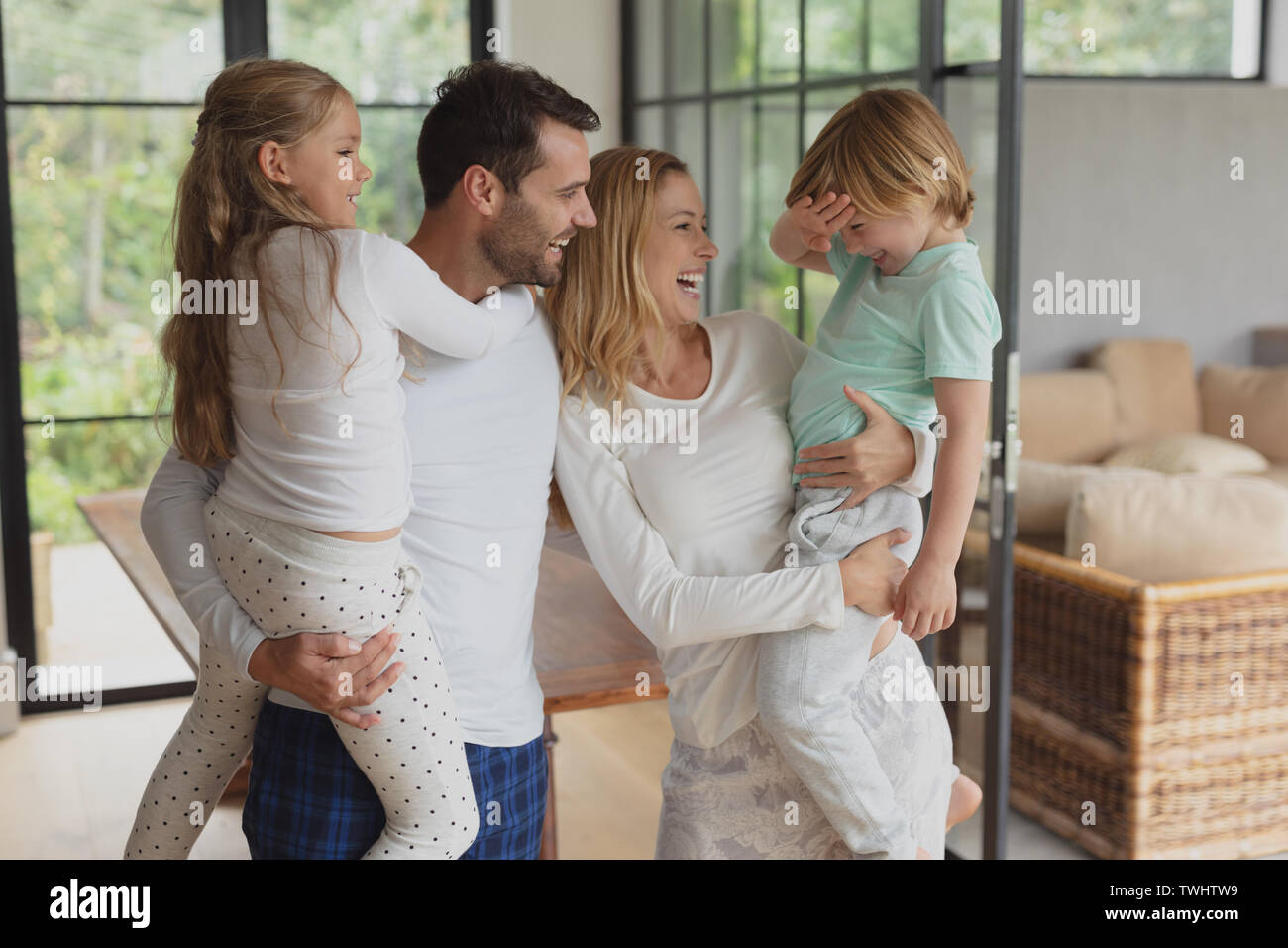 Parents holding their children at home Stock Photo - Alamy