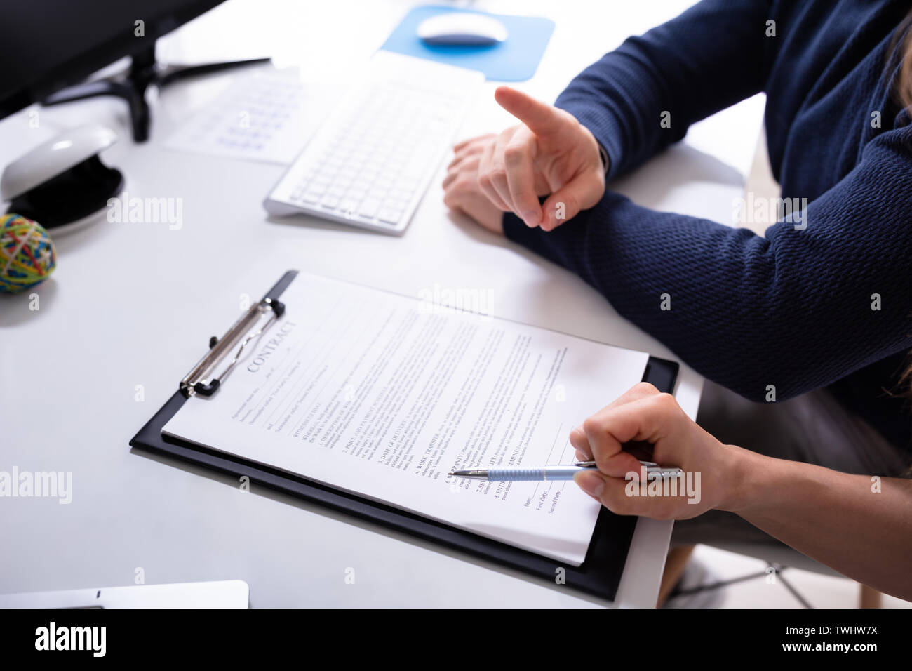 Human's Hand With Contract Agreement On Clipboard Over White Desk In ...