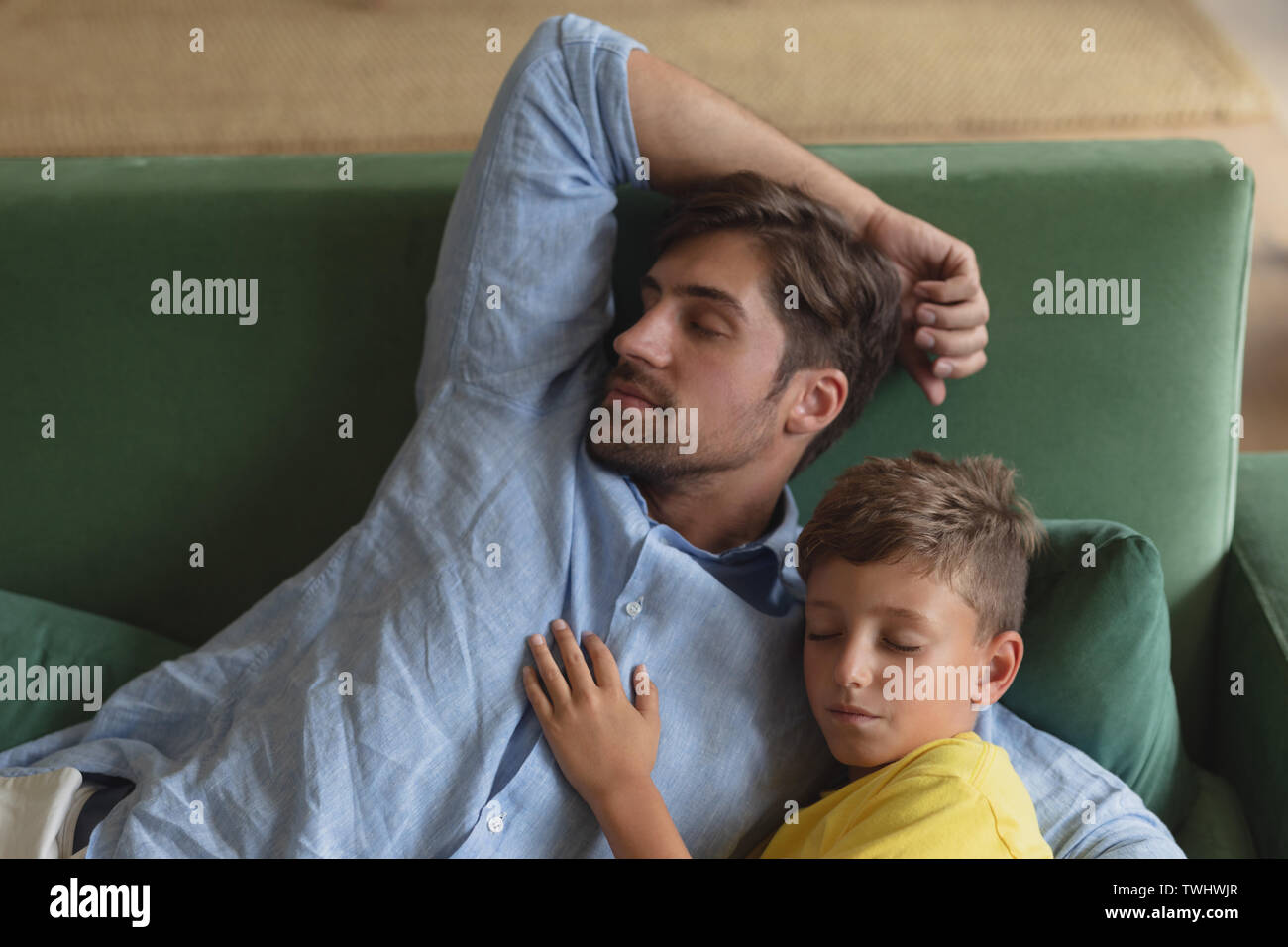 Father and son sleeping together on a sofa in living room Stock Photo ...