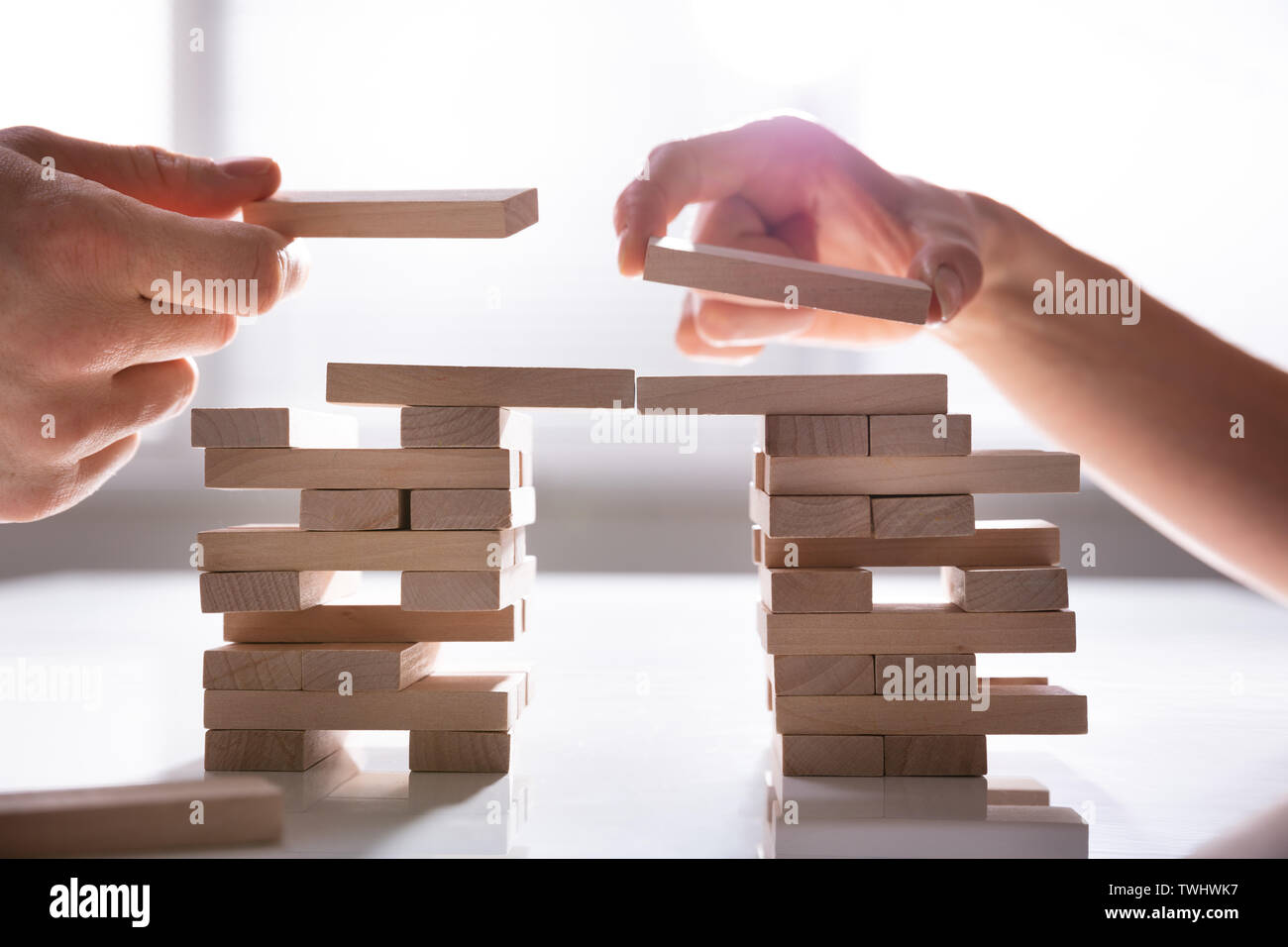 Close-up Of Human's Hand Placing Wooden Block Over Desk Stock Photo - Alamy