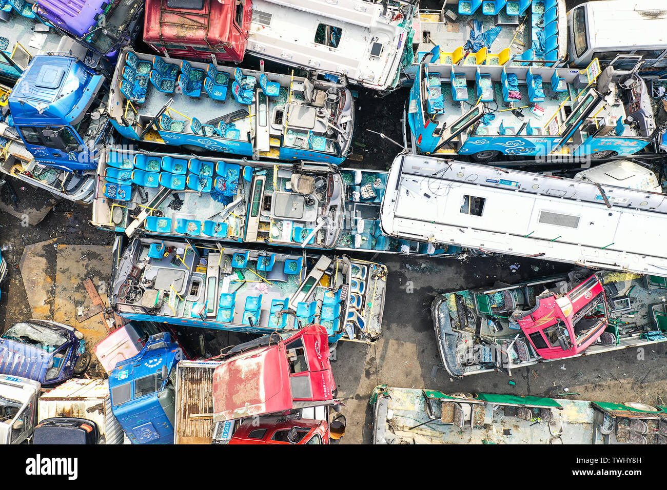 Piled together, scrap-out old motor vehicles waiting to be dismantled ...