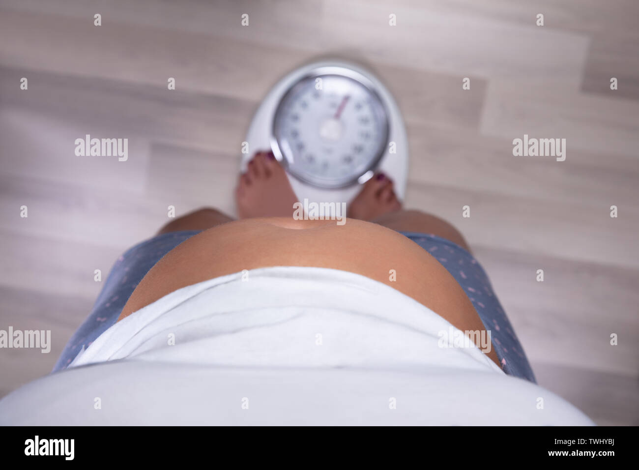 An Elevated View Of A Overweight Woman Standing On The Scale Over ...