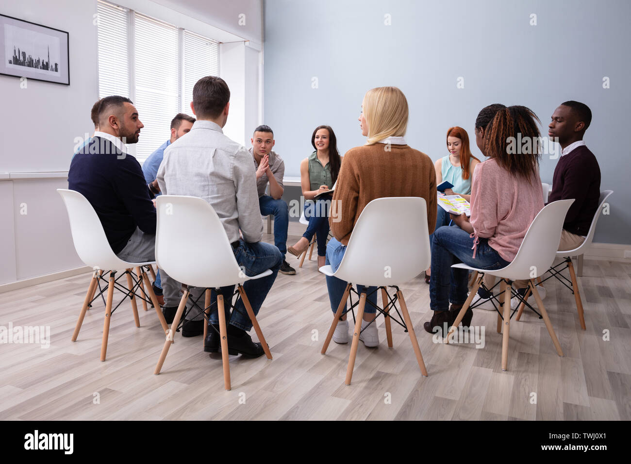 Young Multiracial Millennial Friends Sitting In Circle Having Group ...
