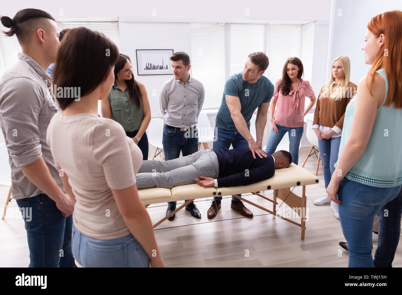 Male Instructor Teaching Massage Technique To Group Of Multi-ethnic ...