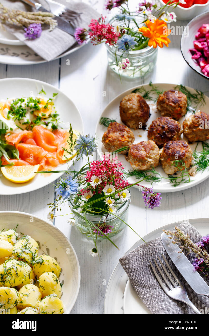 Scandinavian midsummer feast with potato salad, meatballs, salmon and ...