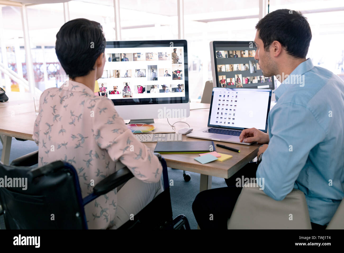 Graphic designers working together at desk in a modern office Stock ...