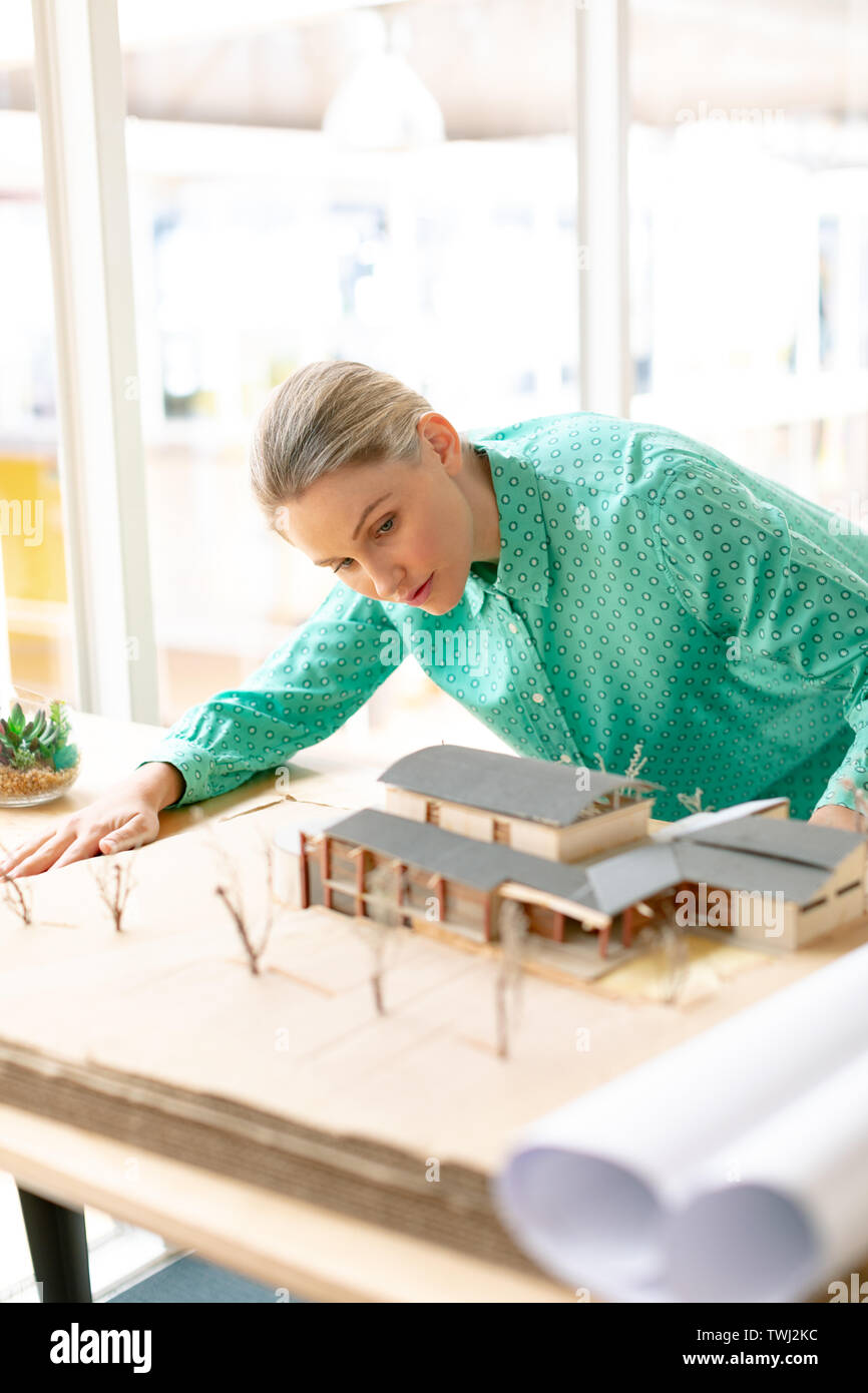 Female architect looking at architectural model Stock Photo - Alamy