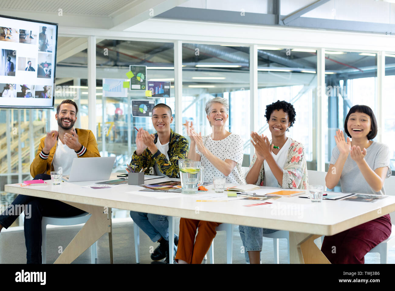Business people clapping hands while sitting in the meeting at the ...
