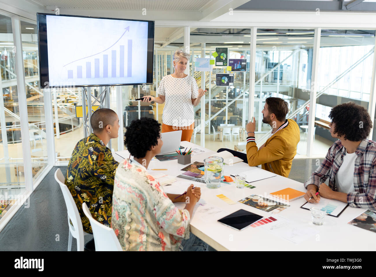 Businesswoman giving presentation on screen during meeting in a modern ...