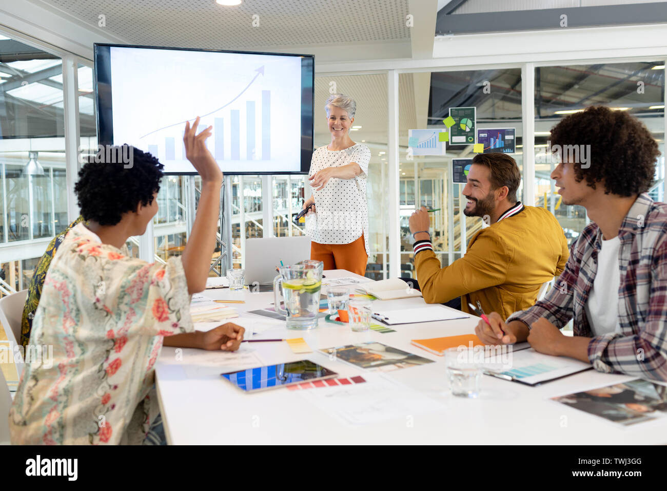 Businessman raising hand in presentation during meeting in a modern ...
