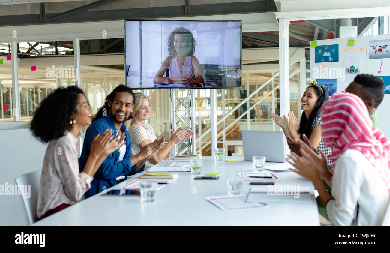 Business people applauding during video conference at conference room ...
