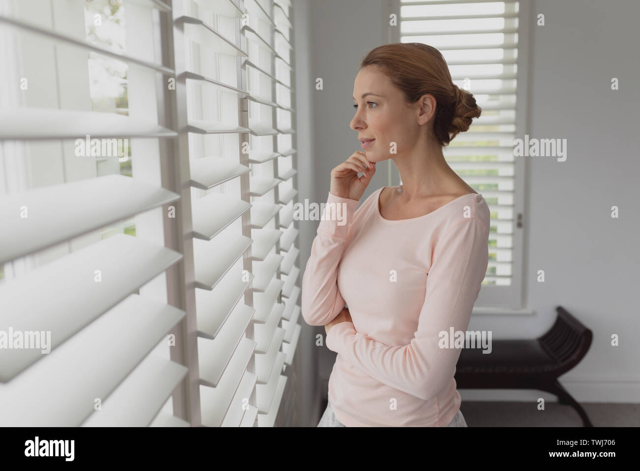 Beautiful woman looking outside through window Stock Photo - Alamy