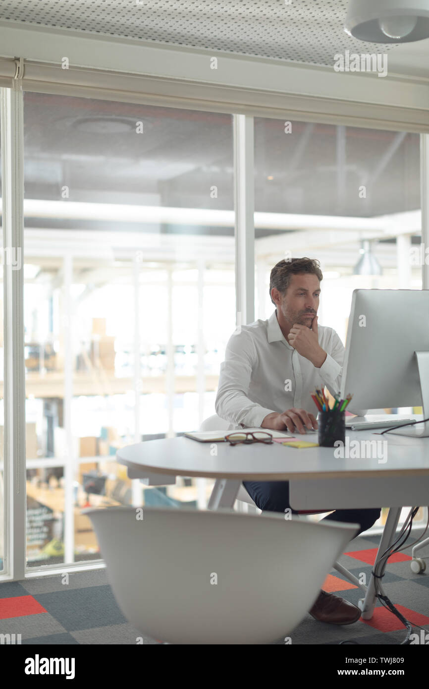 Business male executive working on computer at desk in a modern office ...