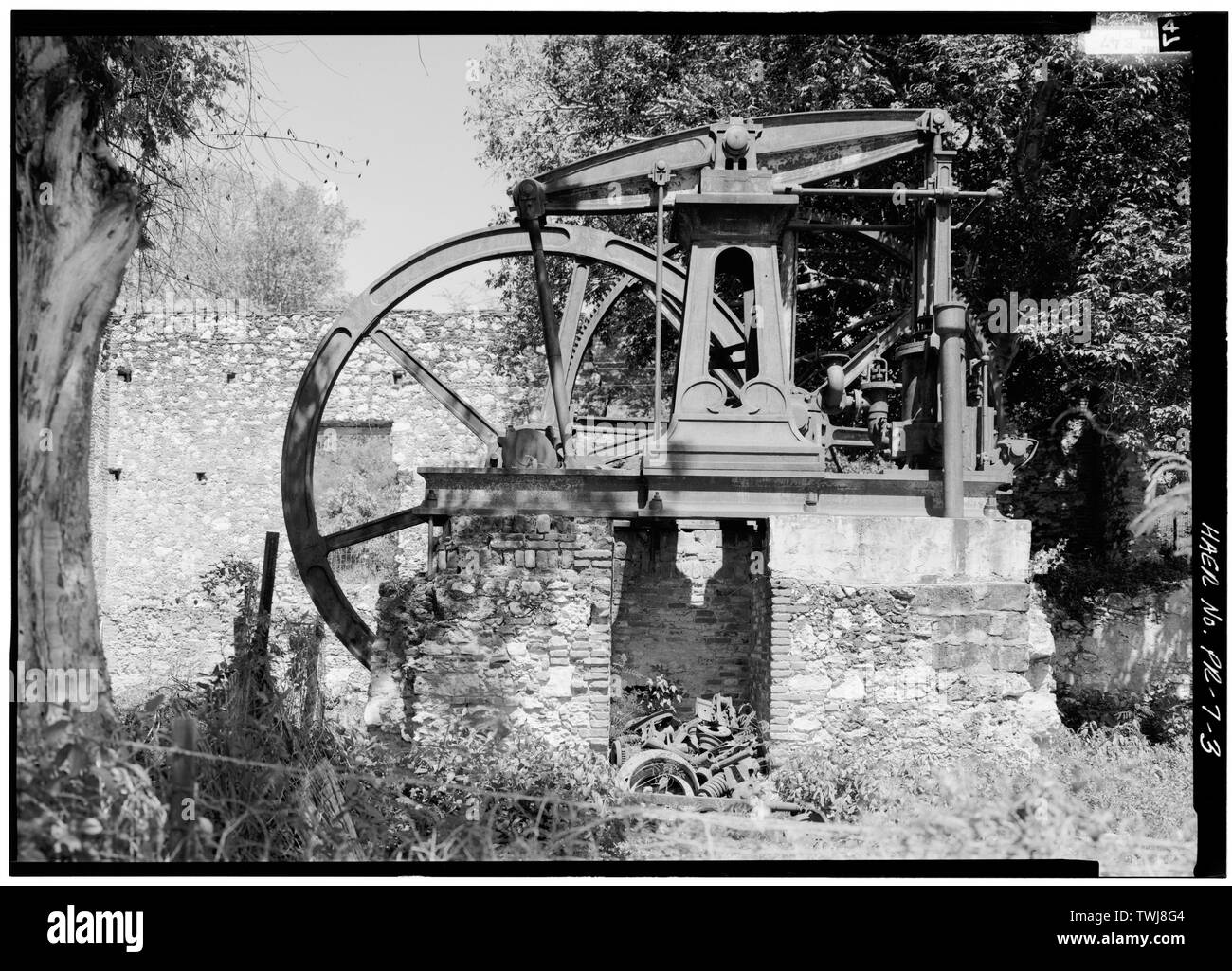 Side view looking E at steam engine with flywheel in background ...