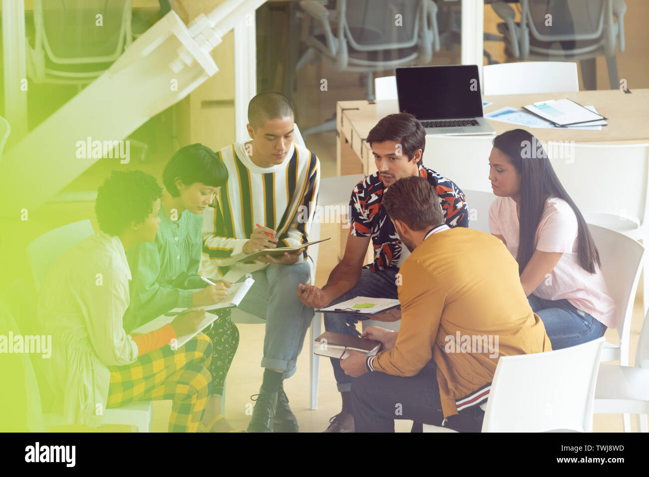 Business people sitting together and having group discussion in office ...