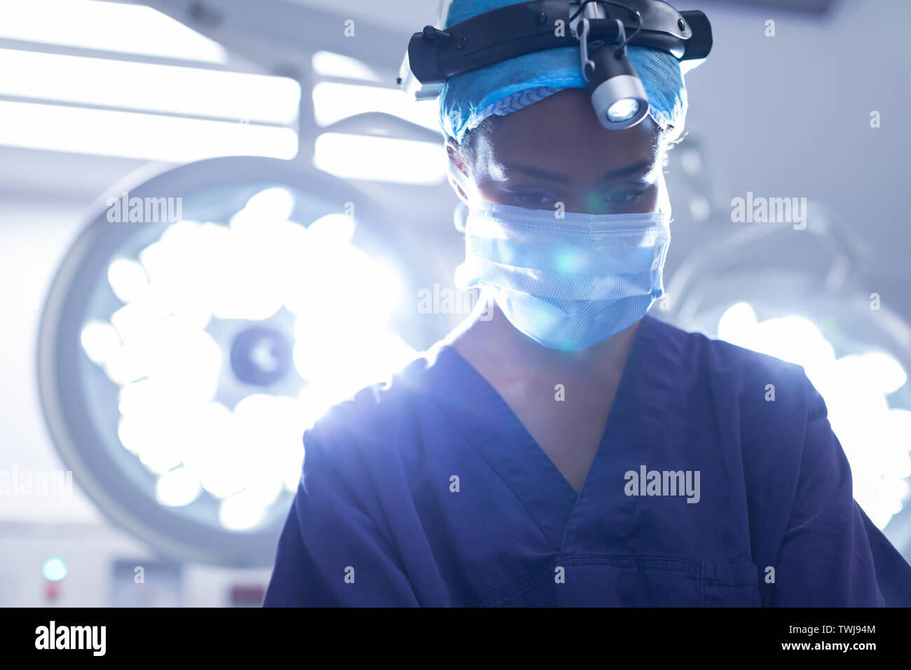 Female with surgical headlight performing operation in operation ...