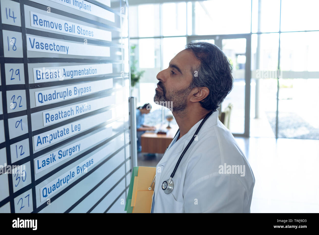Male doctor checking his shifts on chart at hospital Stock Photo - Alamy