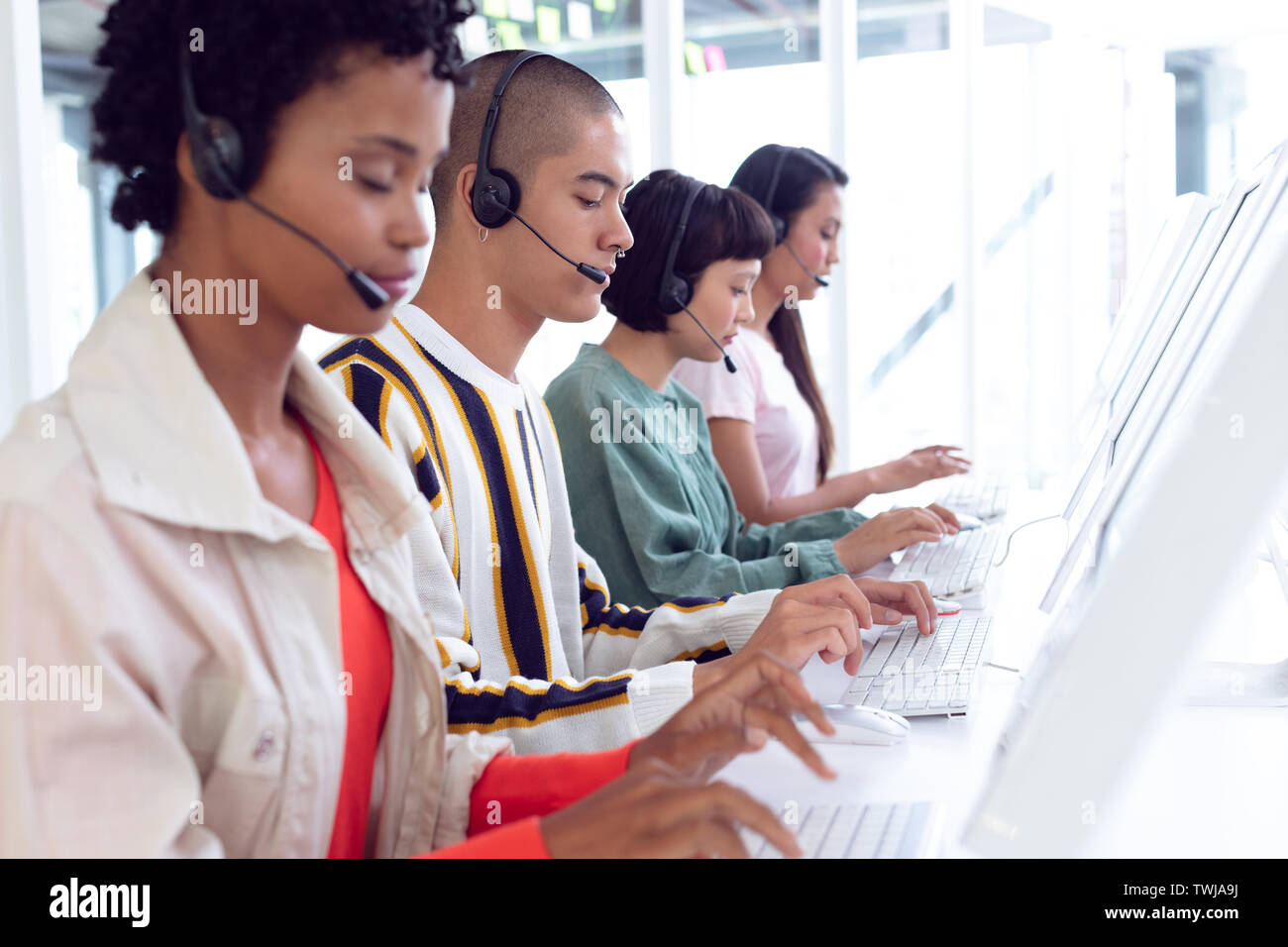 Customer service executives working on computer at desk Stock Photo - Alamy