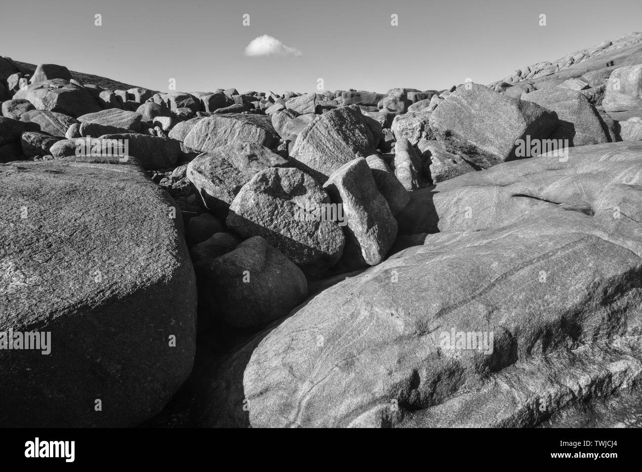 Boulder strewn landscape with single cloud in the sky Stock Photo - Alamy