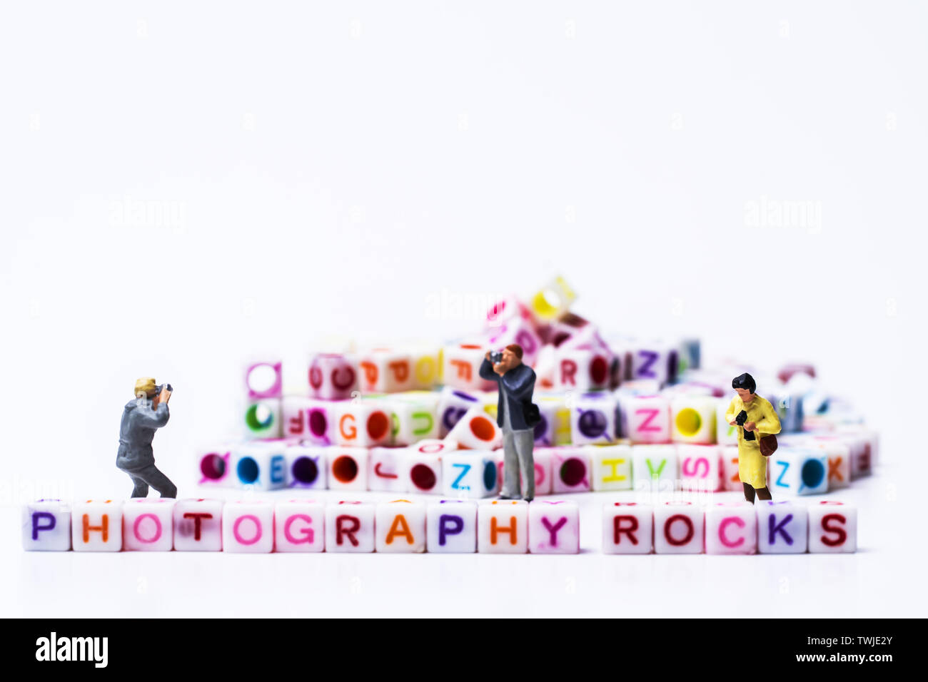 Miniature Photographers taking pictures before a Group Of Letters ...