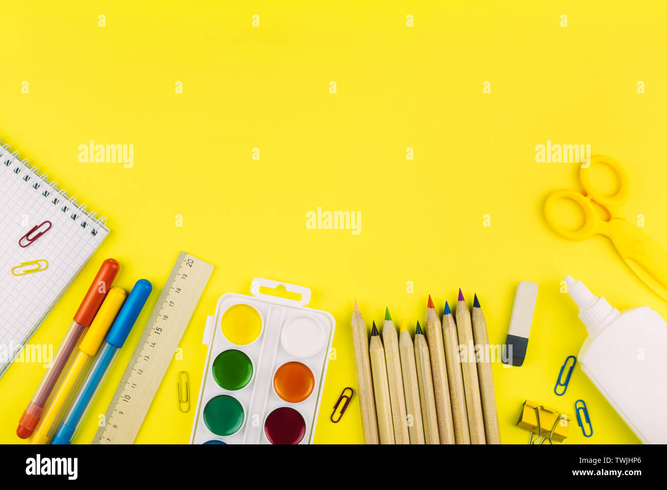 Different school supplies on bright yellow paper background Stock Photo ...