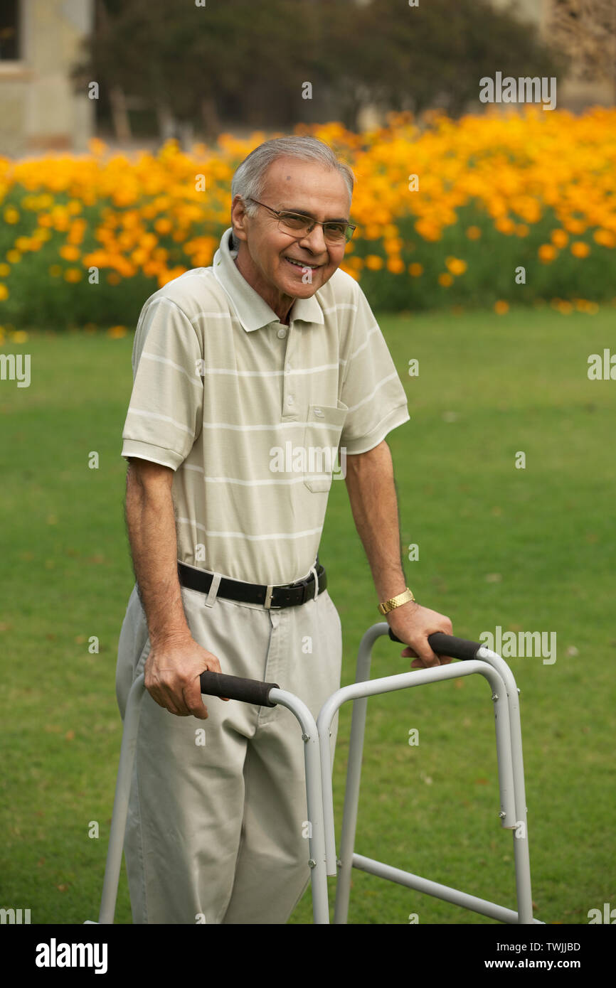Old man walking with a walker Stock Photo - Alamy