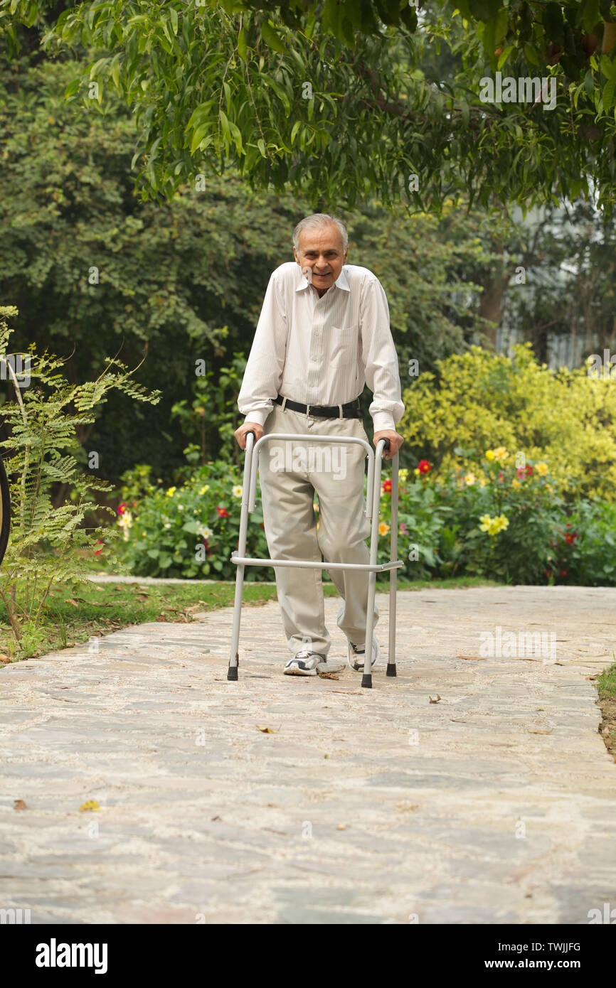 Old man walking with a walker Stock Photo - Alamy