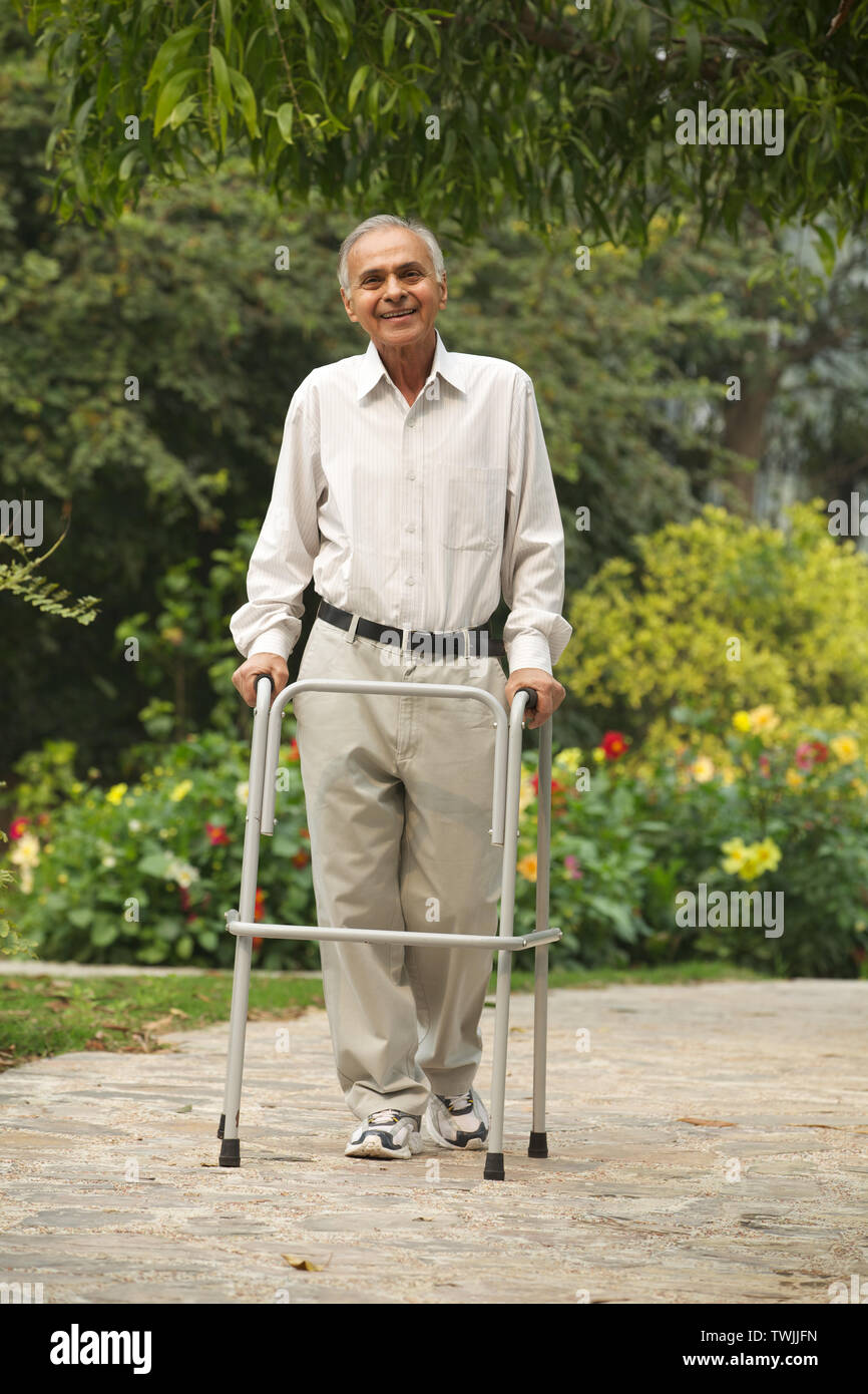Old man walking with a walker Stock Photo - Alamy