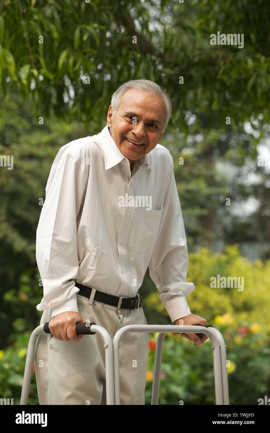 Old man walking with a walker Stock Photo - Alamy