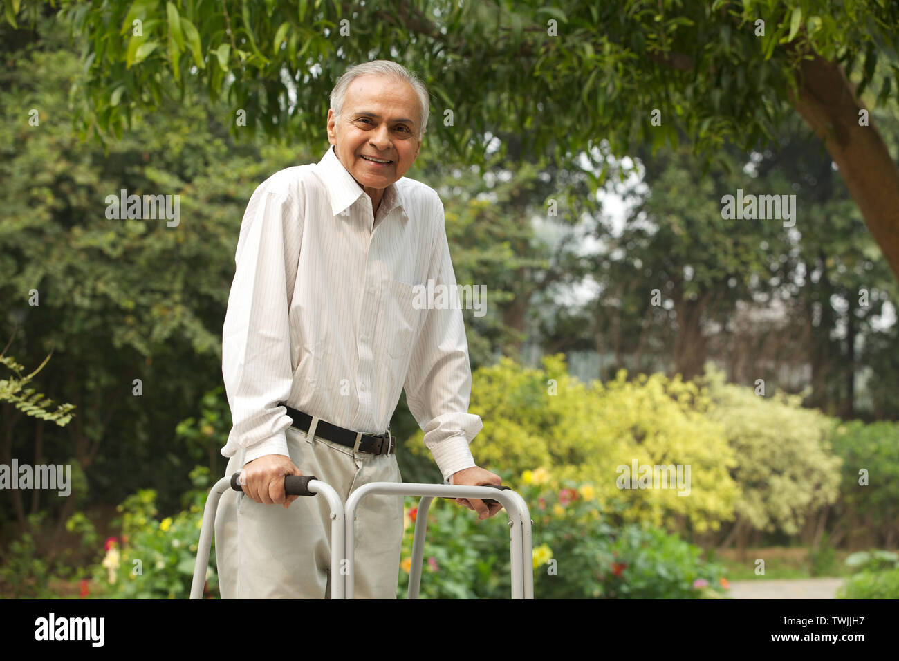 Old man walking with a walker Stock Photo - Alamy