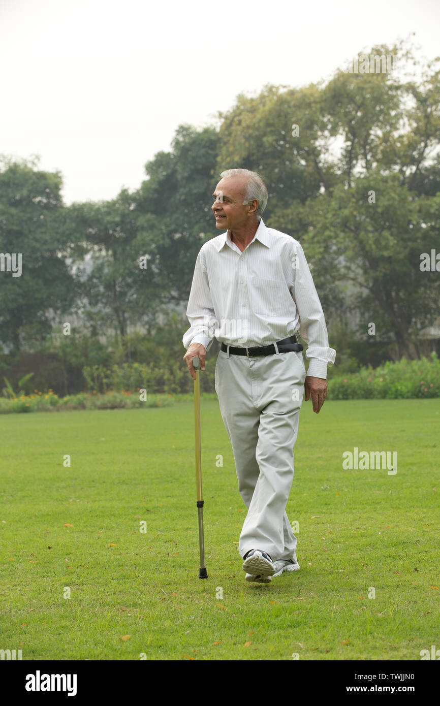 Old man walking with a cane Stock Photo - Alamy