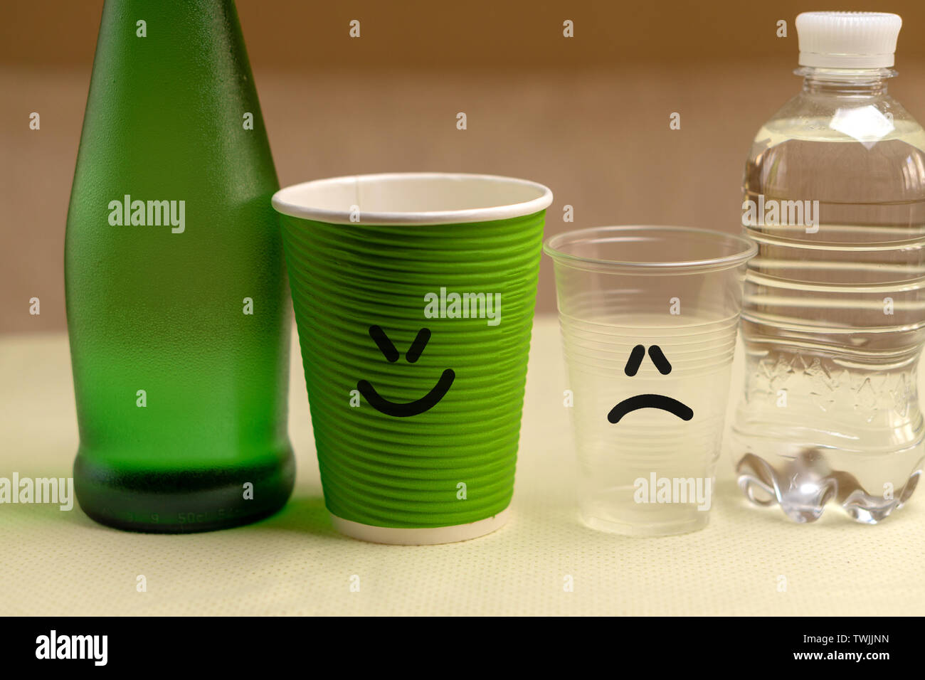 Glass bottle with pure mineral drinking water and a paper cup and a ...