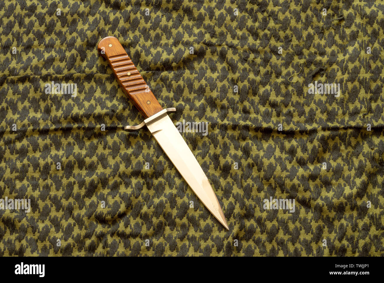 Dagger with wood handle against the background of green keffiyeh Stock ...