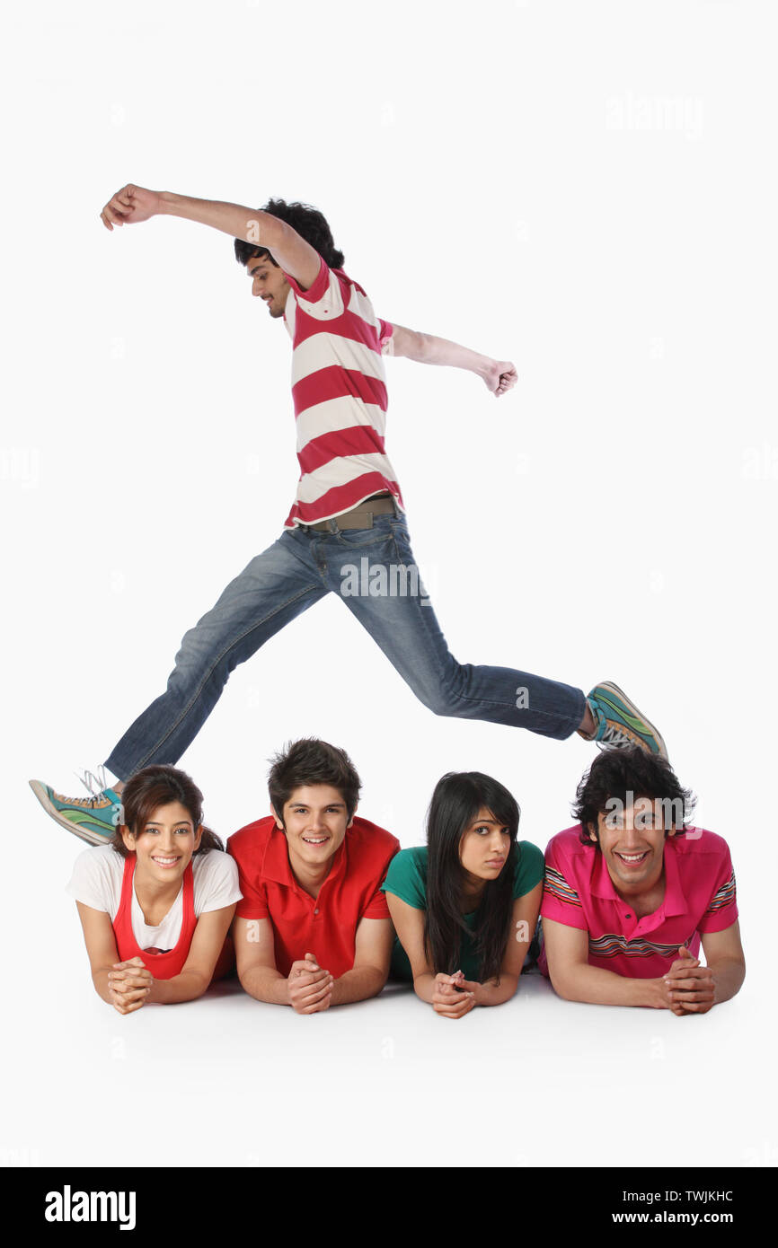 Teenage boy jumping over friends hi-res stock photography and images ...