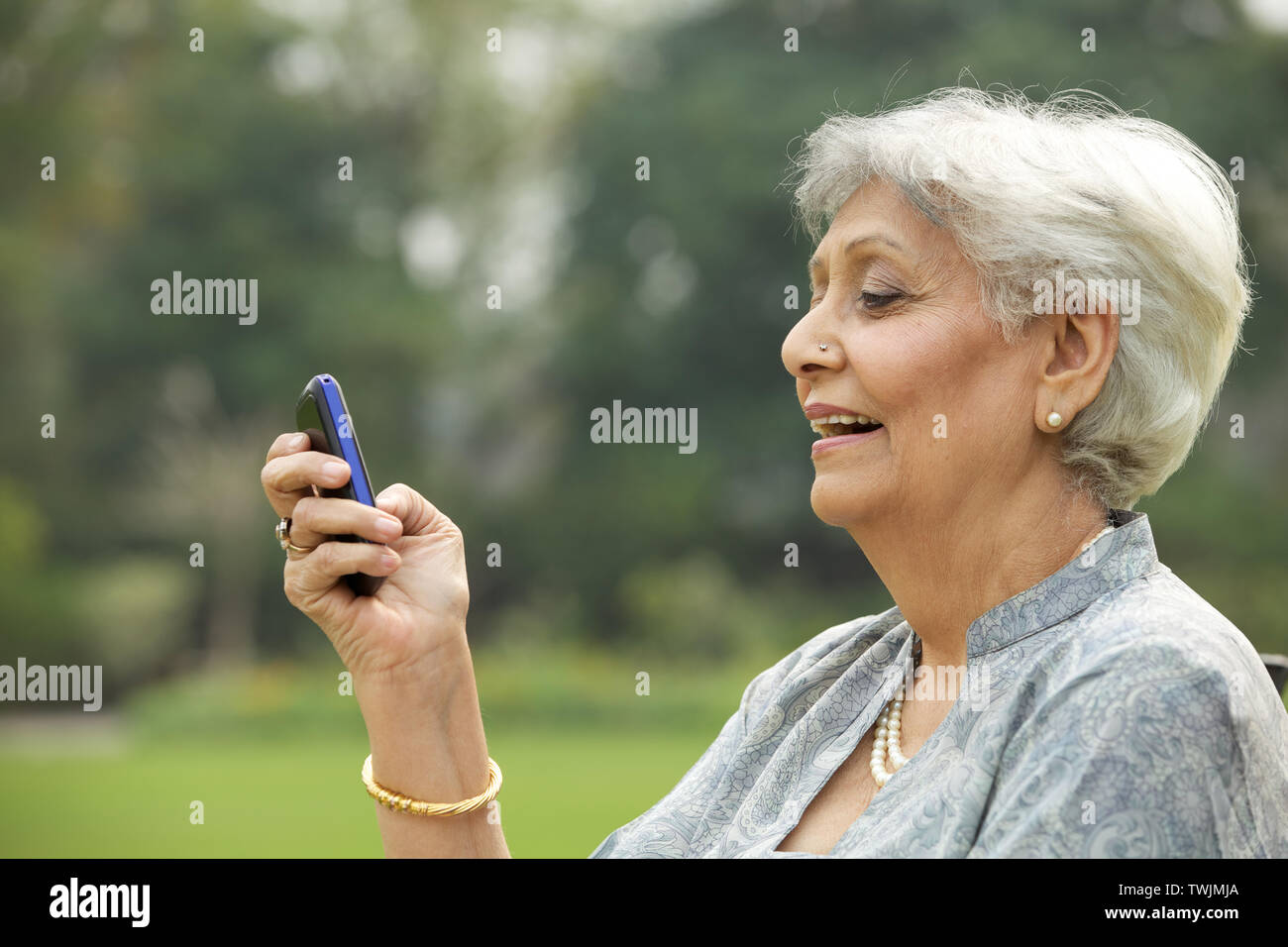 Old woman text messaging and smiling Stock Photo - Alamy