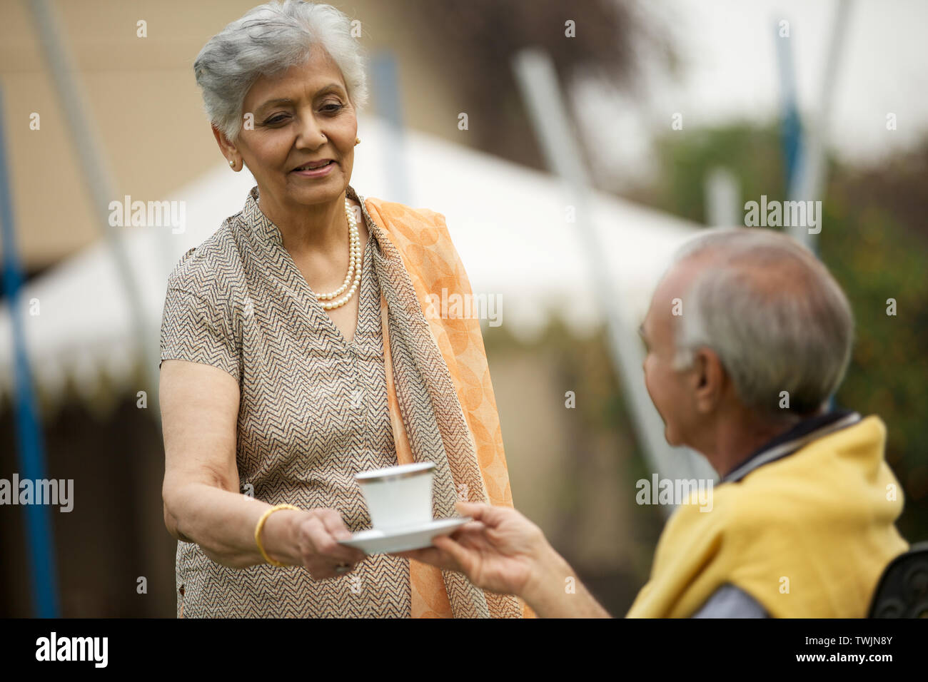 Old woman giving a cup of tea to her husband Stock Photo - Alamy